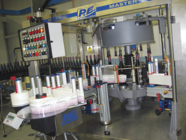 A high-speed, wine-bottling line at Stone Hill Winery applies screw ca