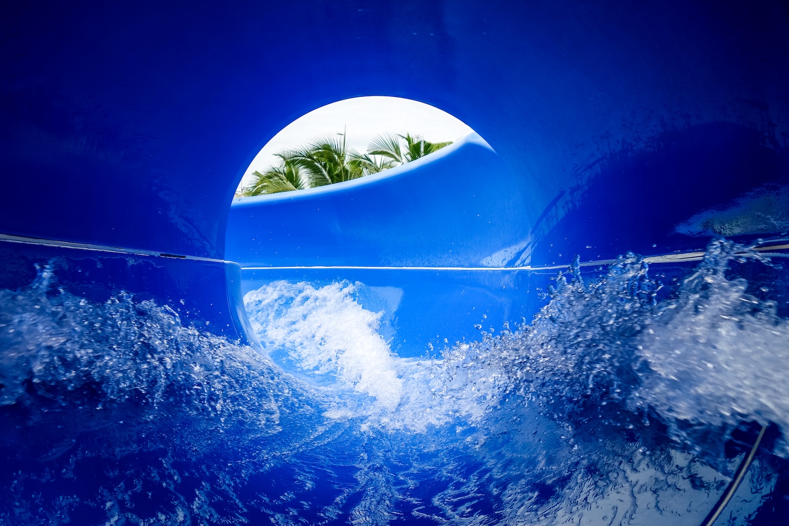 A blue water slide with a wave cascading from its top, inviting thrill ...