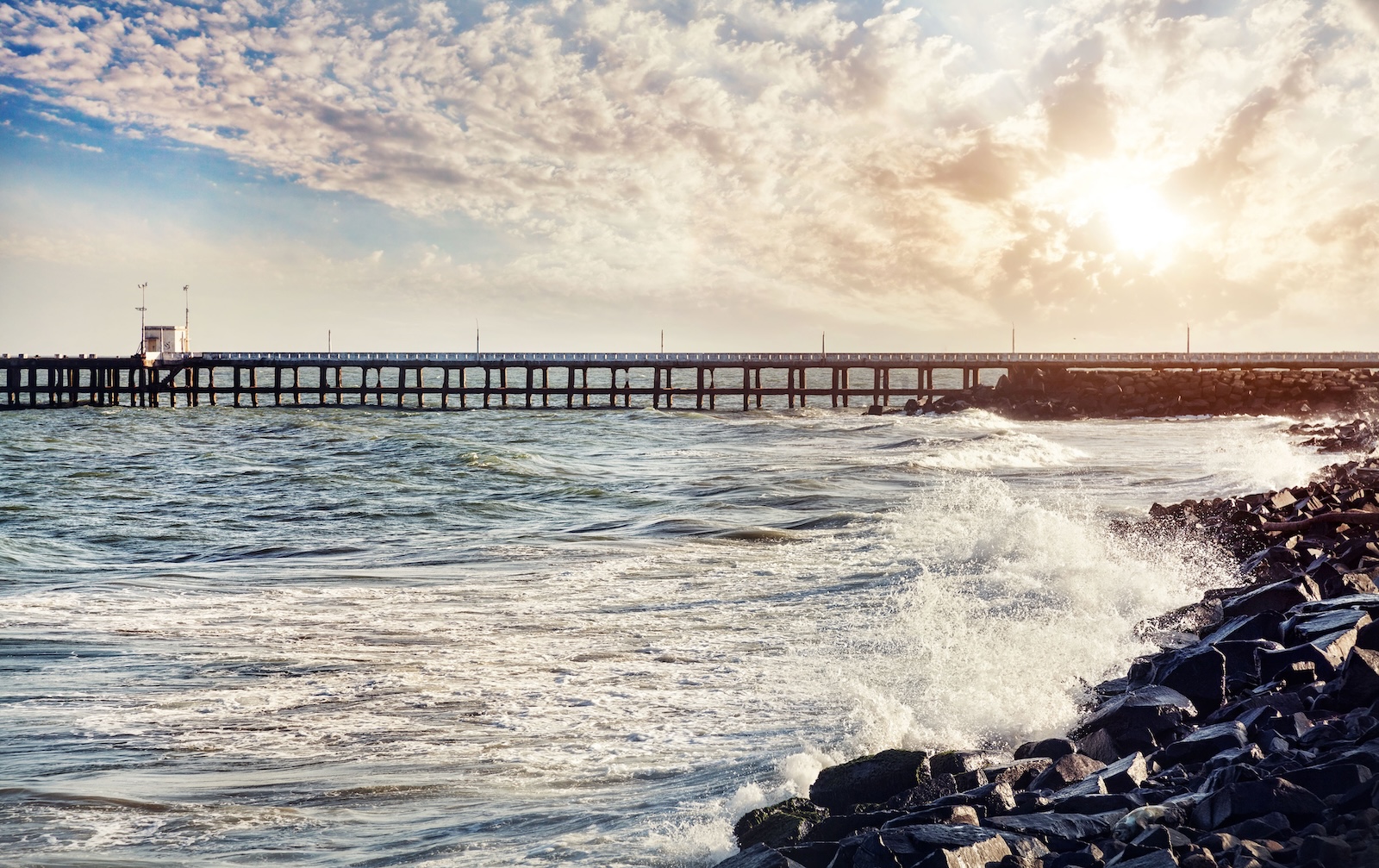 A sunset over Promenade Beach area, with waves crashing against the ...