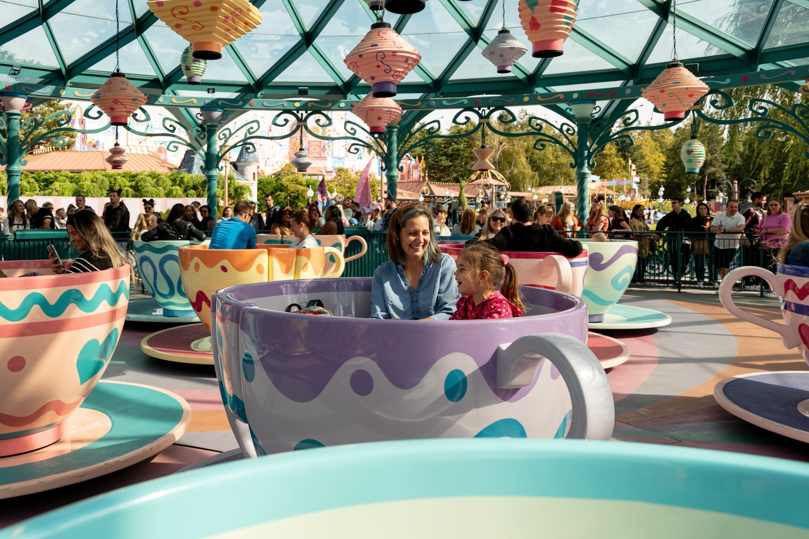 A woman and child enjoy a whimsical tea party, seated in a giant tea ...