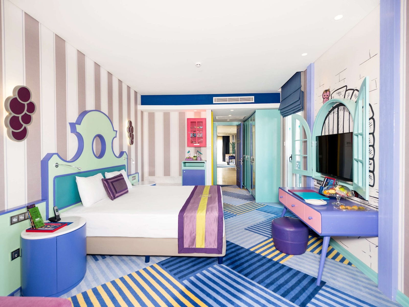A vibrant bedroom in The Land of Legends Kingdom Hotel, featuring a bed ...