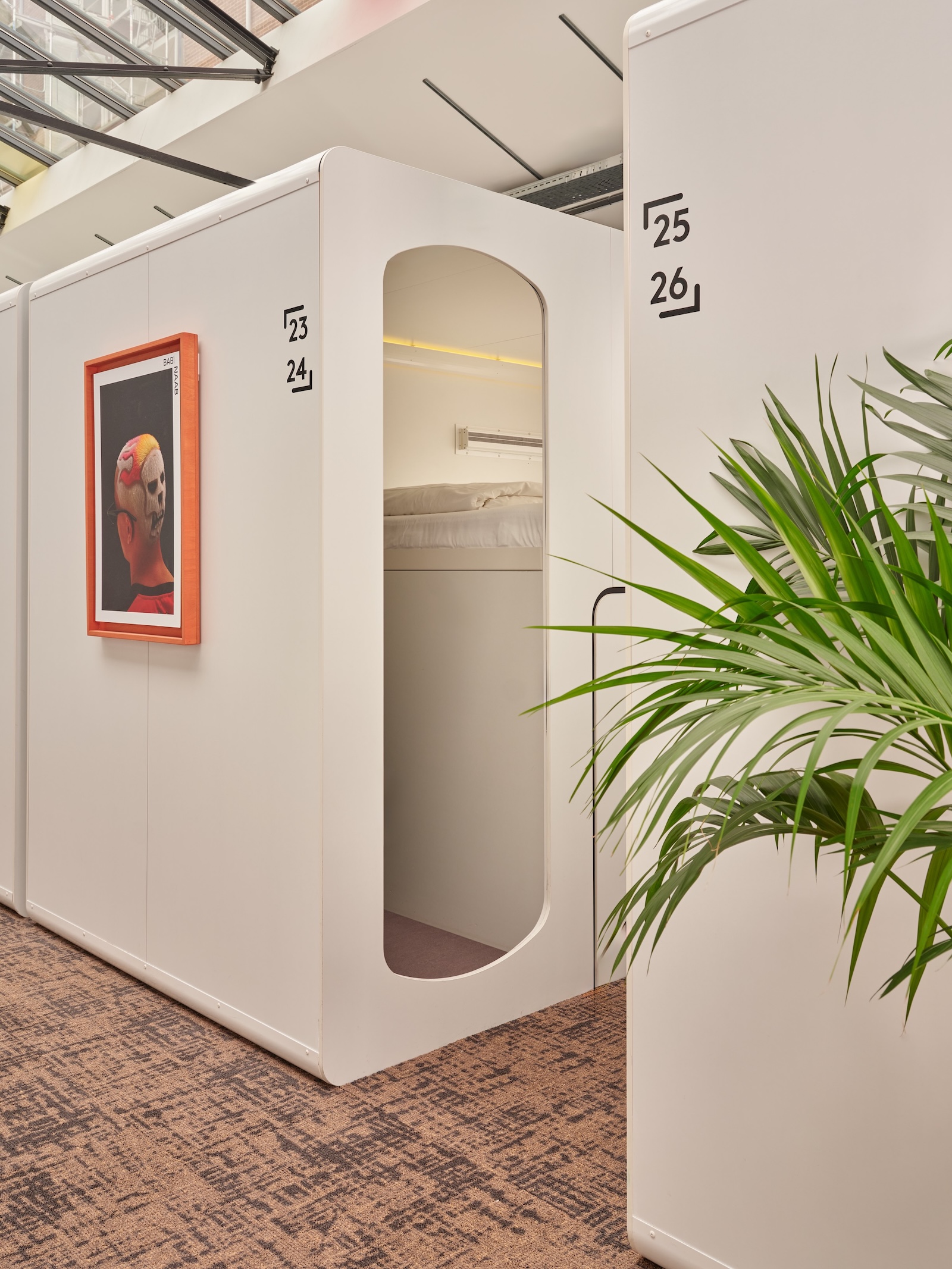 A white capsule pod in CityHub Amsterdam, the room is bright and airy