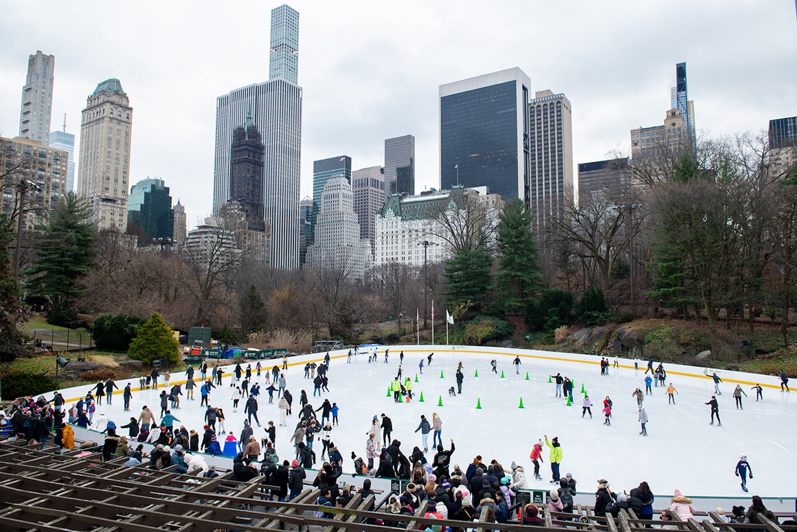 A vibrant city ice rink in New York is filled with people skating ...