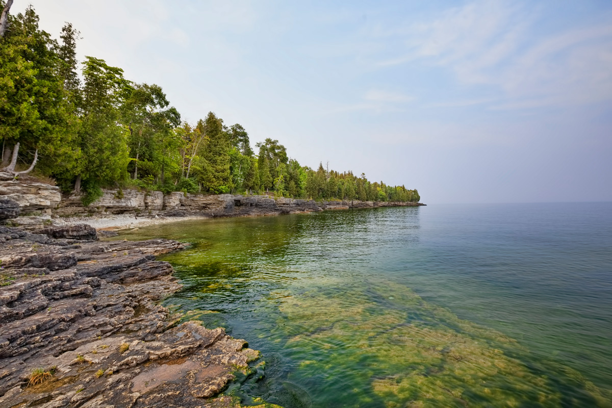 Rocky shoreline with trees adjacent to Lake Michigan in Wisconsin ...
