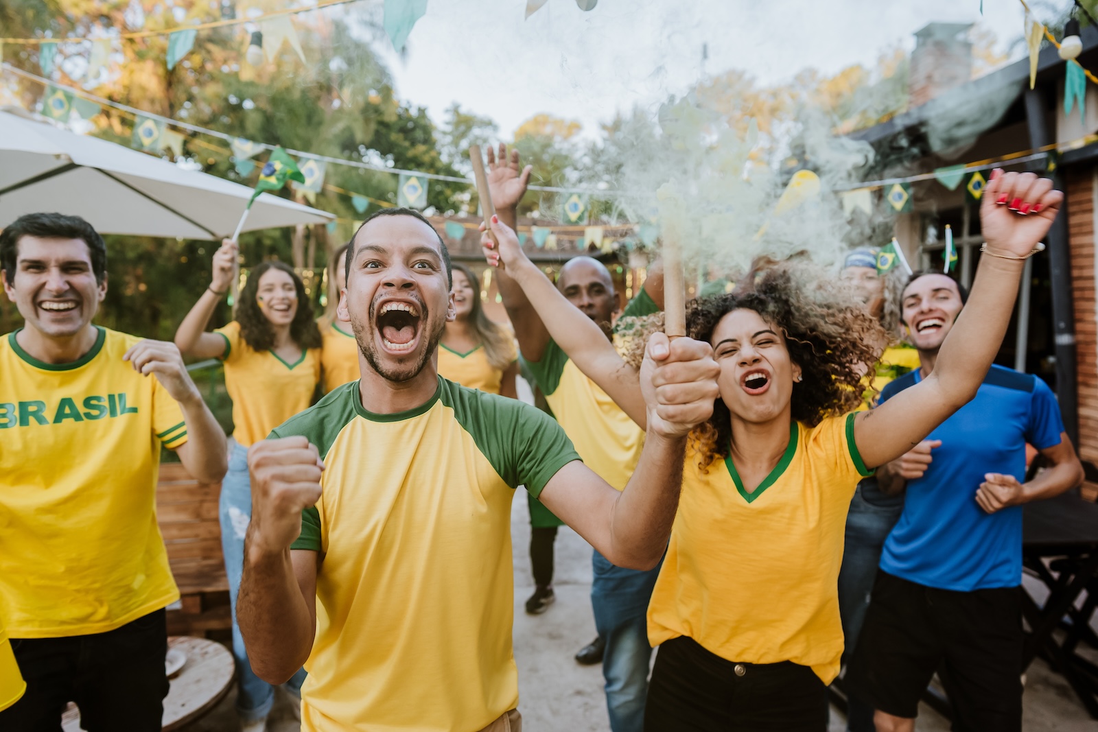 Football fans in Brazil t-shirts cheering and celebrating