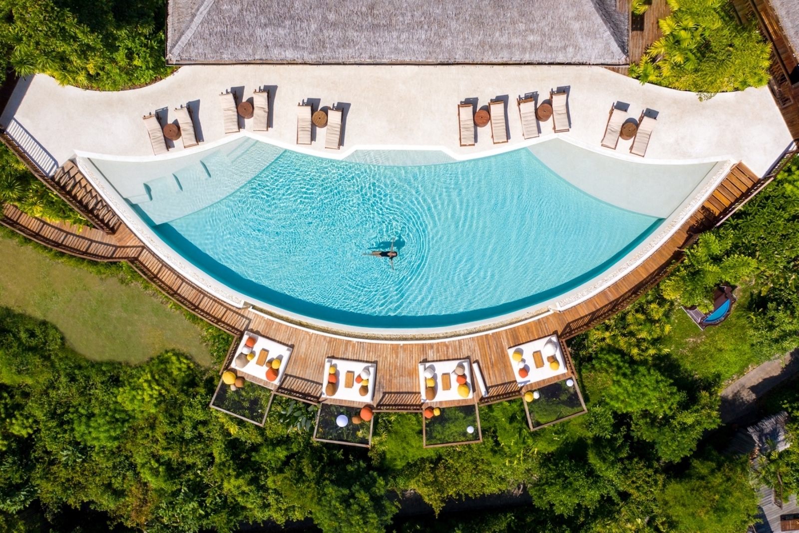 Aerial view of a serene pool nestled among trees at Six Senses Yao Noi ...