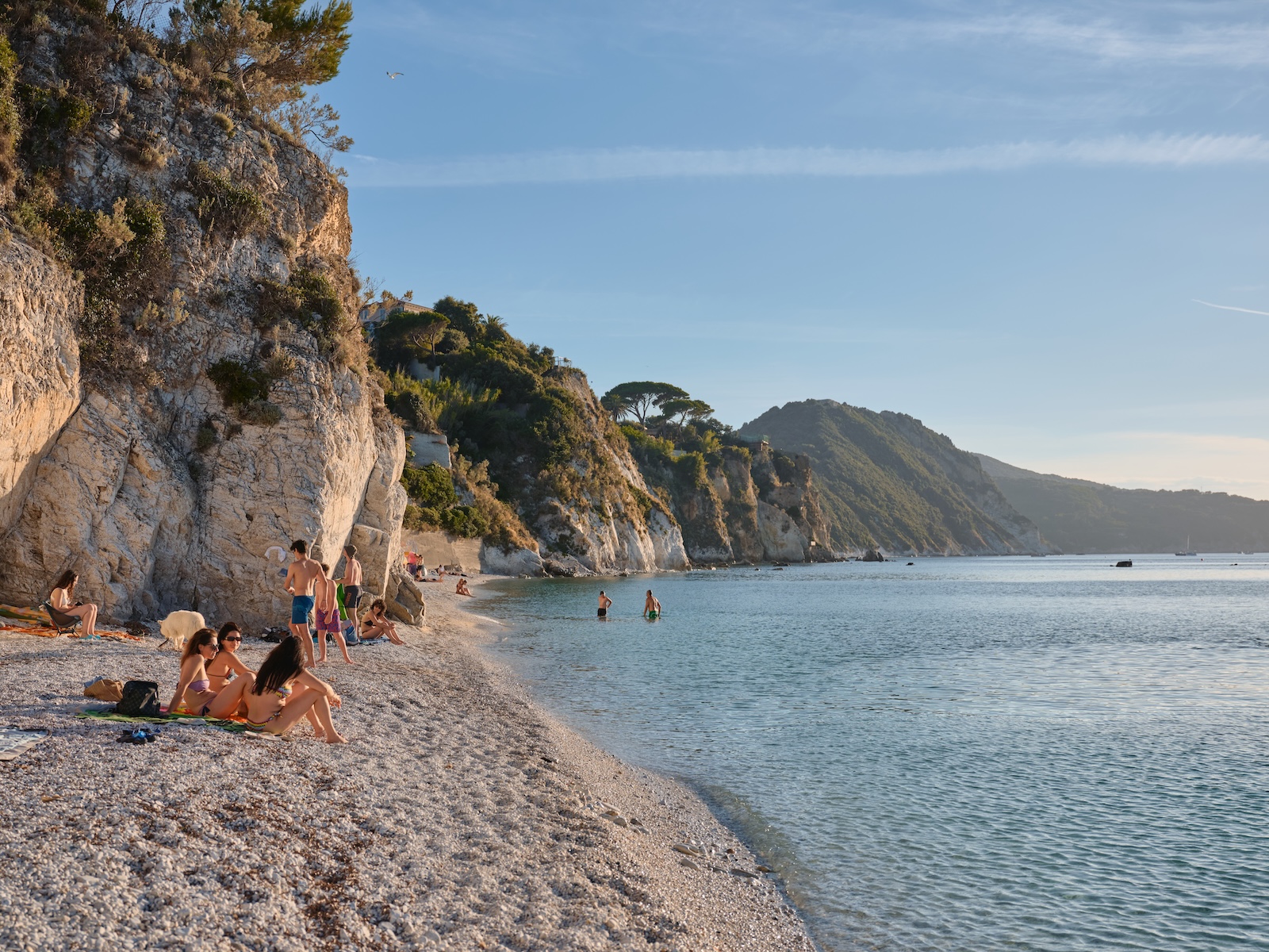 A serene sandy beach on Elba, with gentle waves lapping at the shore ...