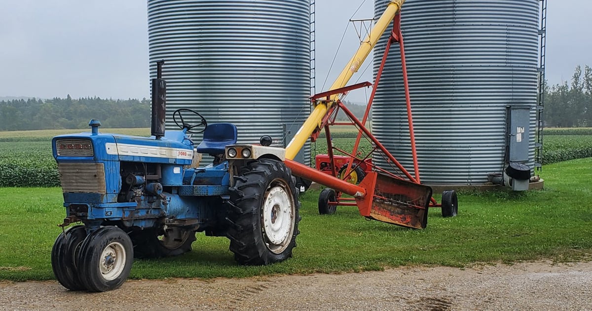 Vintage tractors power augers on modern farms